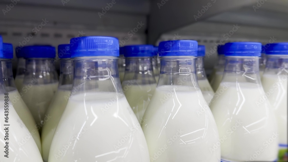milk in plastic bottles on the supermarket shelves. healthy eating ...