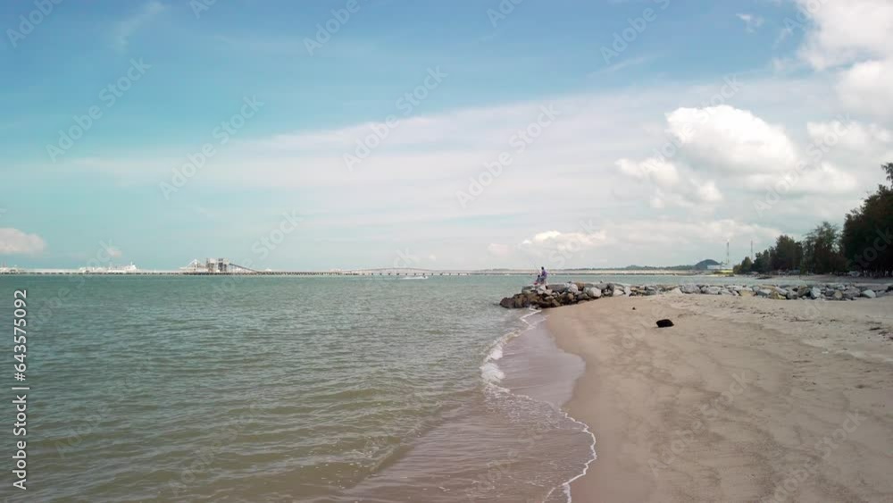 A drone-like low-to-high angle shot captures the coastal serenity of ...