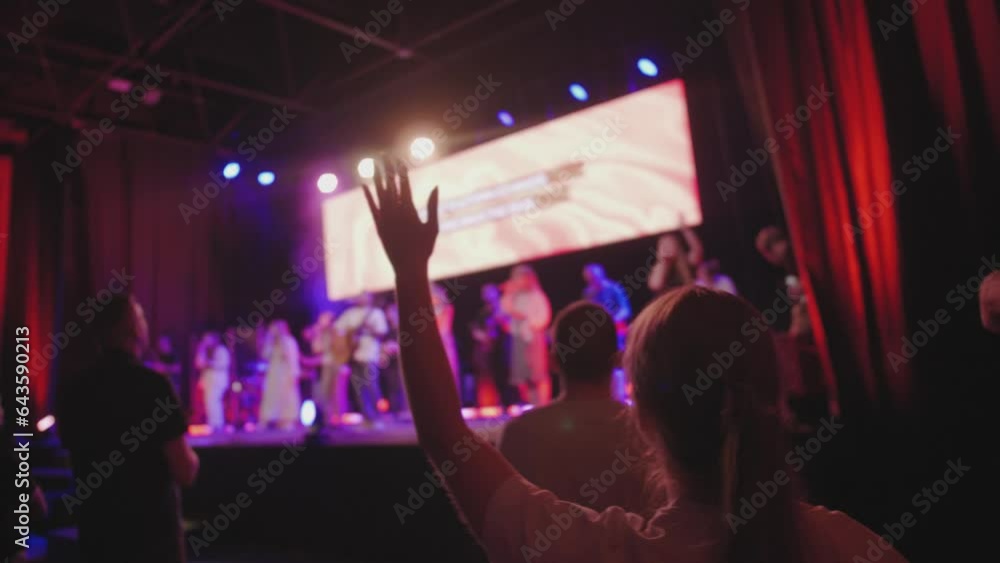 Young girl lifting hand up during christian worship night performing ...