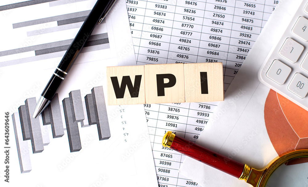 WPI text on wooden block on graph background with pen and magnifier ...
