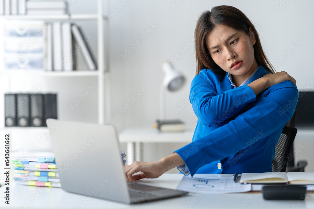 Young businesswoman having pain and fatigue in her shoulders and neck ...