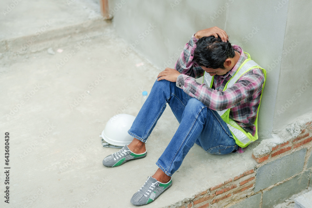Foreman's Discouragement Sitting on cement wall at a construction site ...