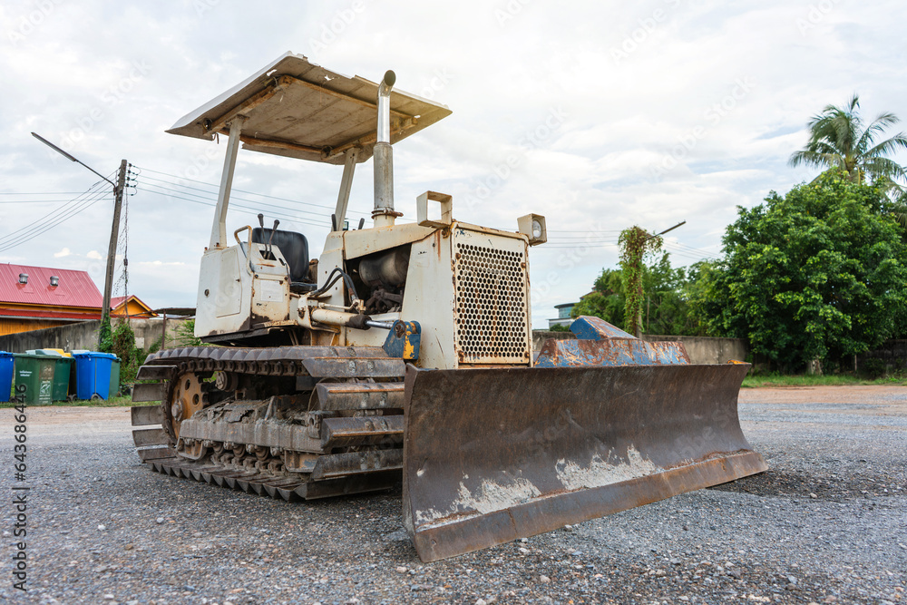 Old white dozer track-type or excavator bulldozer parked on a gravel ...