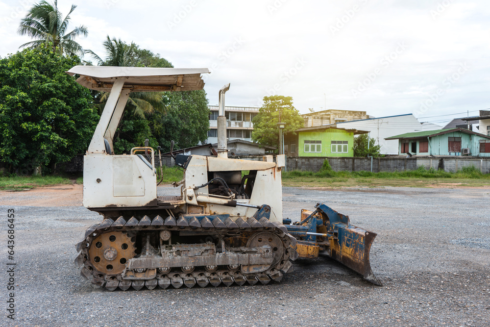 Old white dozer track-type or excavator bulldozer parked on a gravel ...