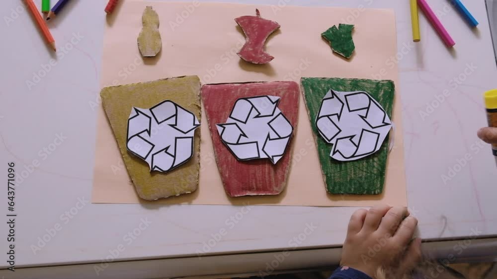 Little girl making poster of garbage containers for sorting at ...