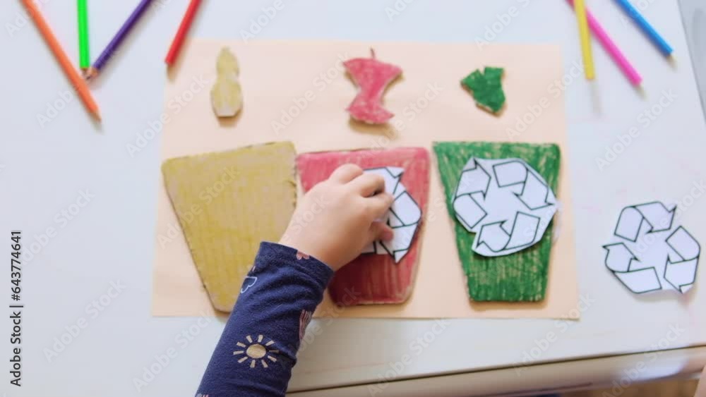 Little girl playing with poster of garbage containers for sorting at ...