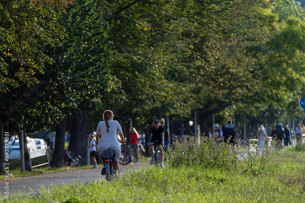 Vibrant park scene: A group of people enjoy an outdoor stroll along a ...