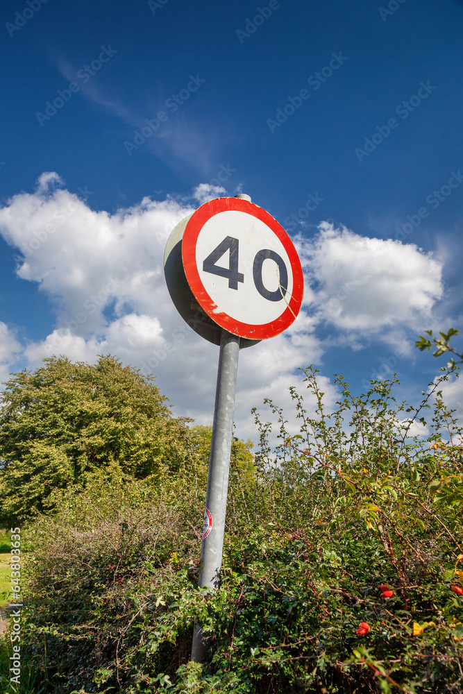 40 mph sign in English countryside, sunny day with blue sky, and white ...