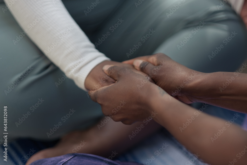 A woman receives a hand massage from her friend. Her friend rubs her ...