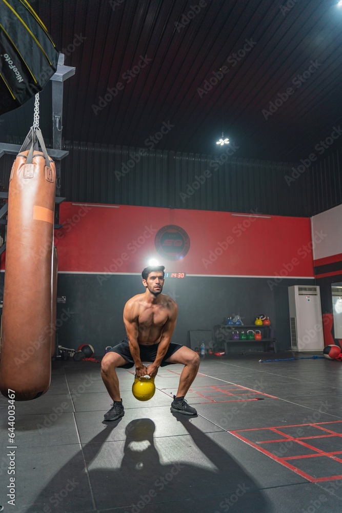 Handsome and muscular Middle Eastern man lifts heavy dumbbells ...