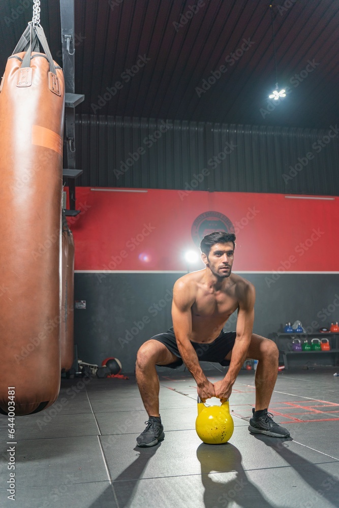 Handsome and muscular Middle Eastern man lifts heavy dumbbells ...