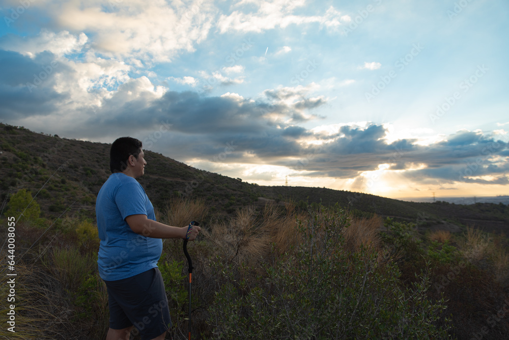 Overweight man stops his training to contemplate the landscape in the ...
