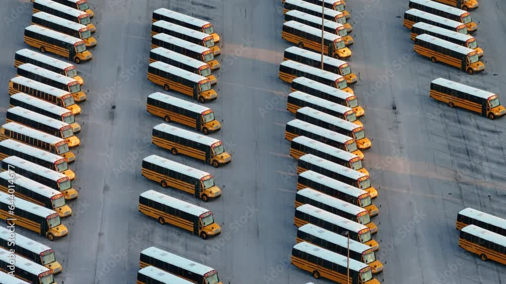 Public school bus parking lot with many yellow buses parked in rows ...