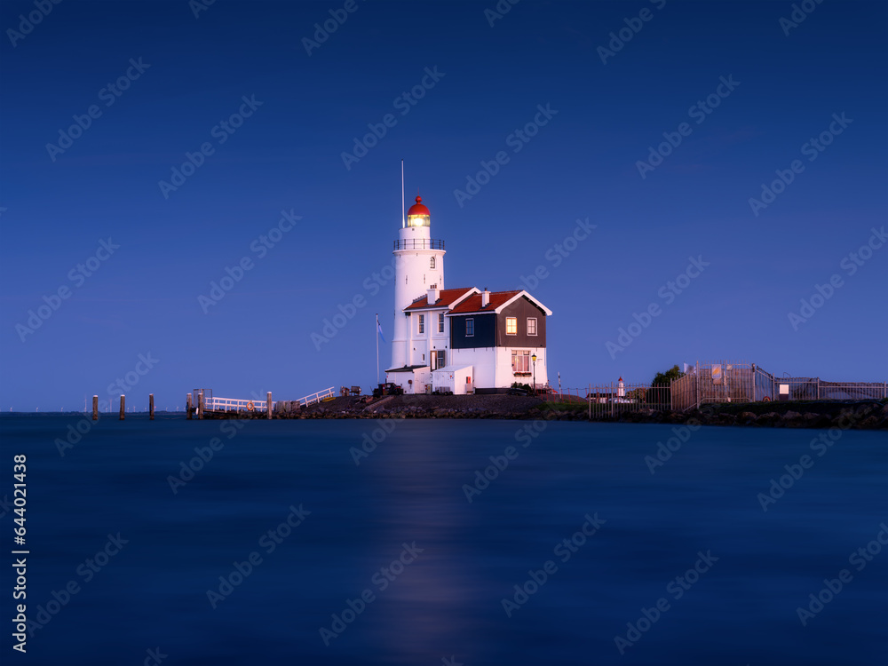 A lighthouse on the beach during blue hour. A landmark in maritime ...
