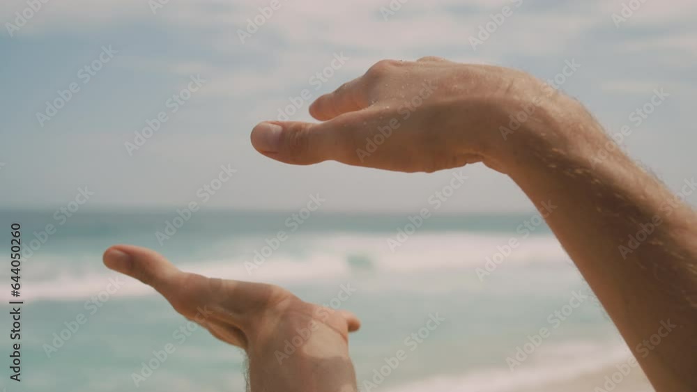Close-up man moving hands as if controlling power of sea waves. Strange ...