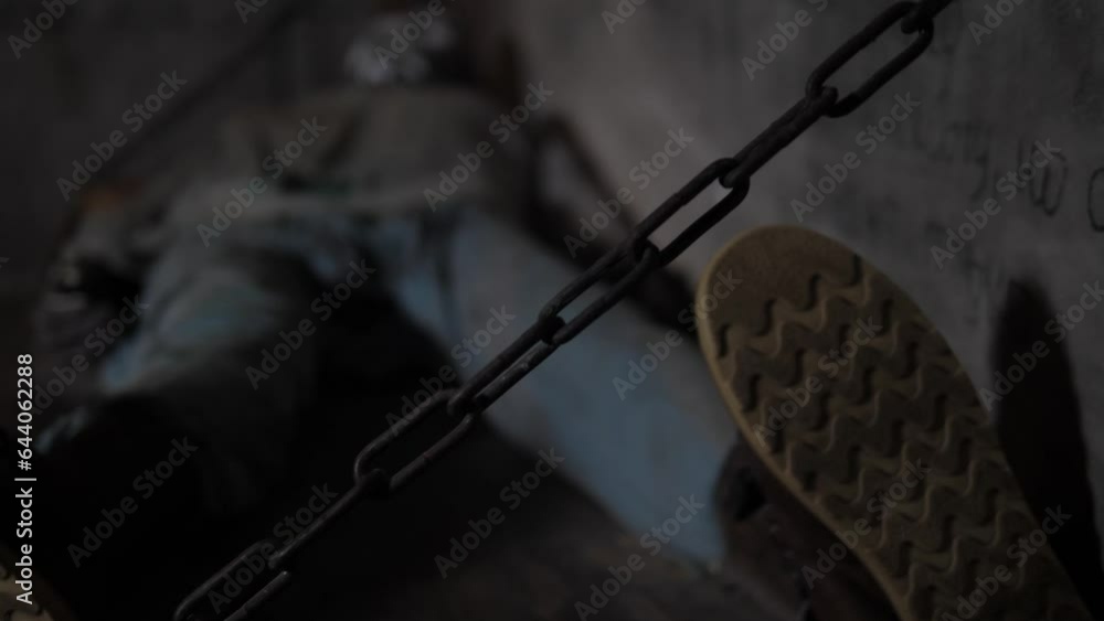 A close-up of the shoe of a terrible mannequin in a dark room, a ...