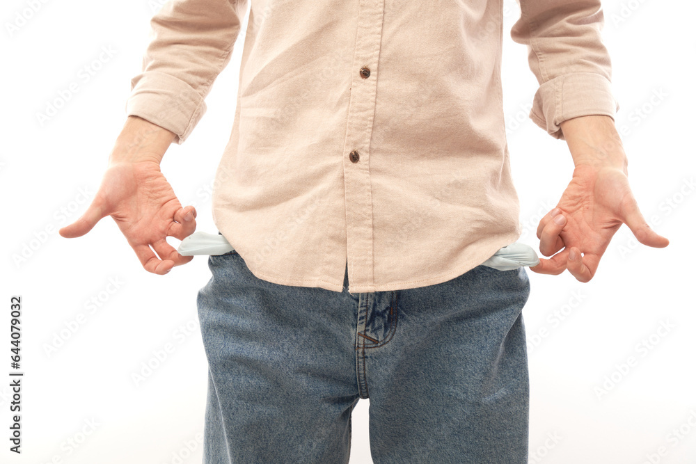 Portrait of broke businessman showing empty pockets isolated on white studio background with ...
