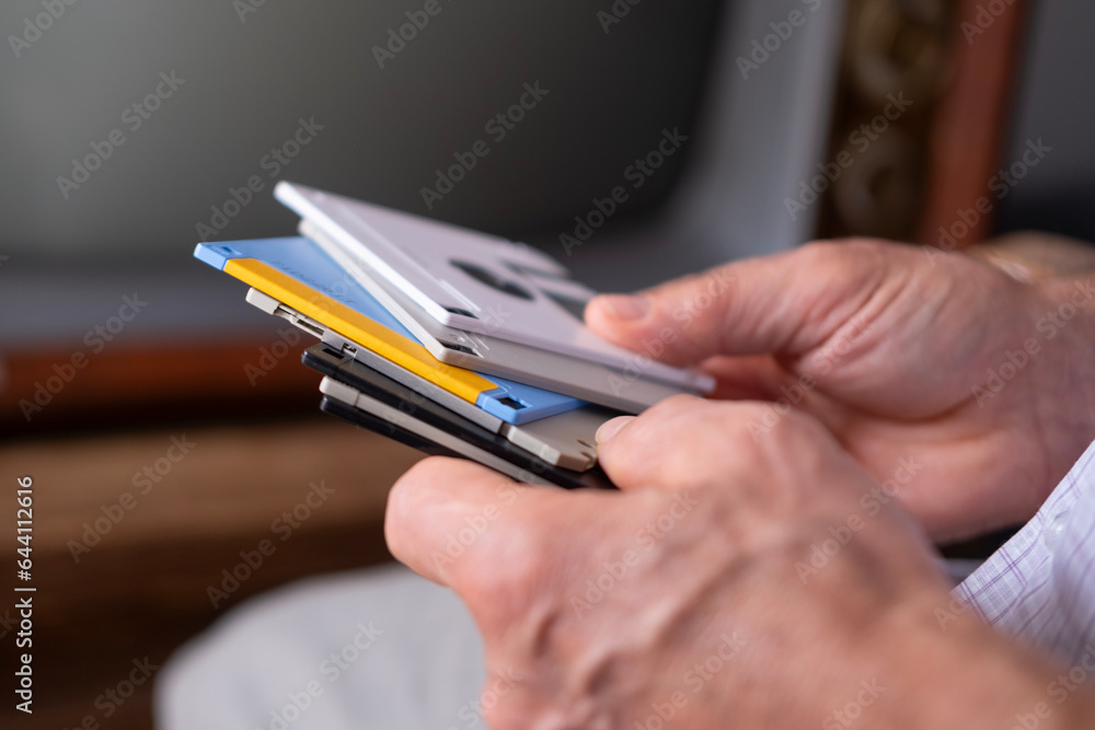 mature male hand holding vintage electronic data storage devices ...
