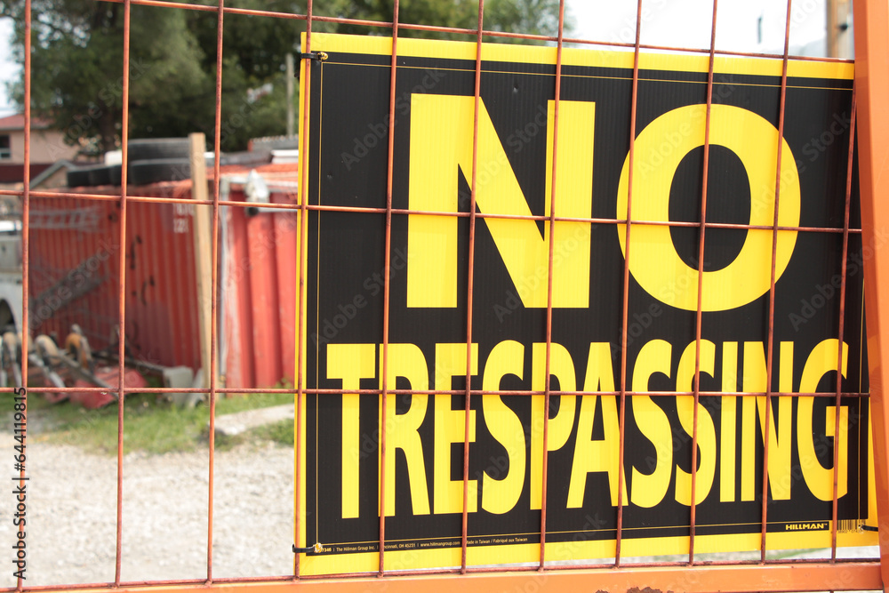 no trespassing signs on orange locked gate for dirt yard parking lot ...