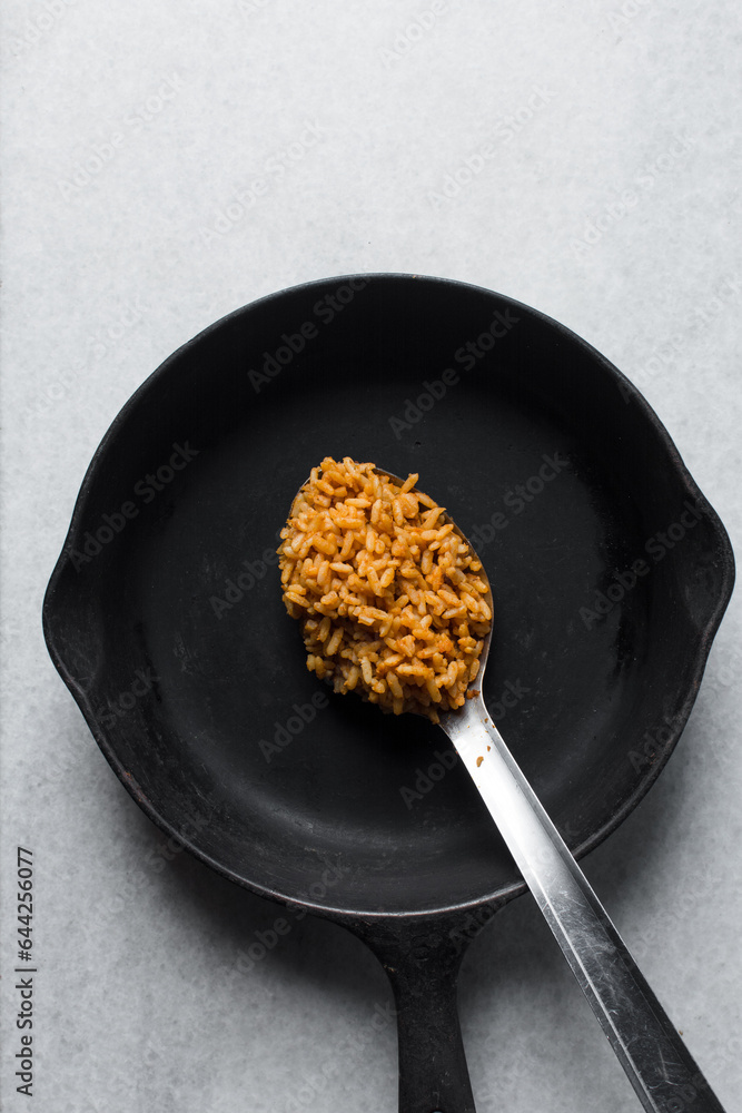 Spoon of Jollof rice in a cast iron skillet, homemade party nigerian ...