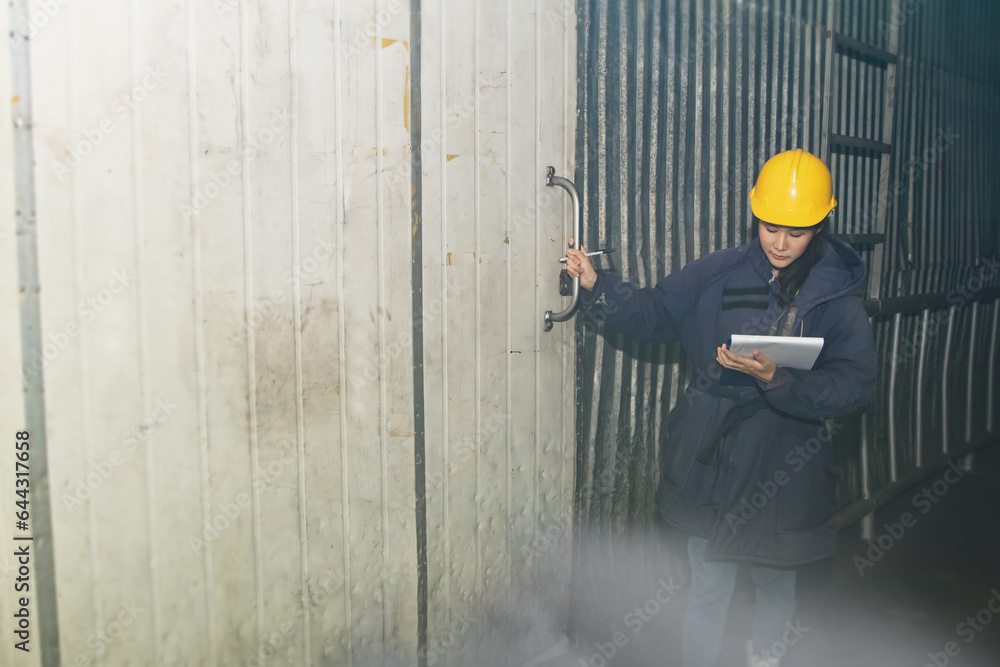 Female employee inspects the low temperature raw material storage room ...