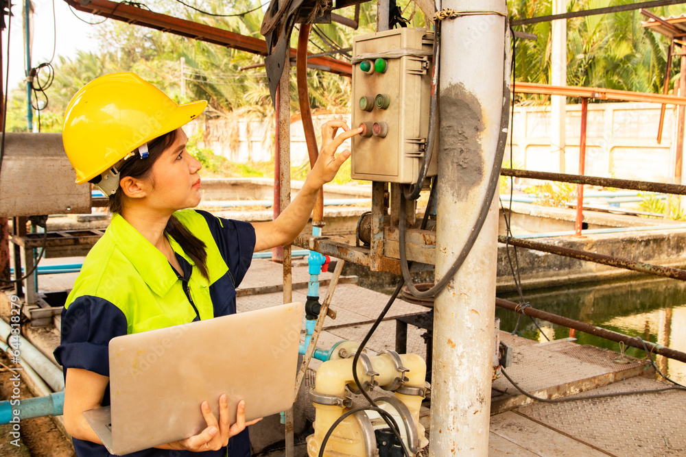 Female technician worker holding laptop inspects control system air ...