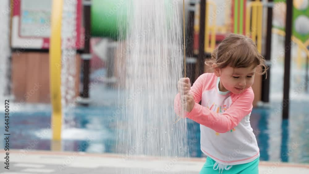 Playful Little Girl at Water Playground Drags Rope to Start Shower ...