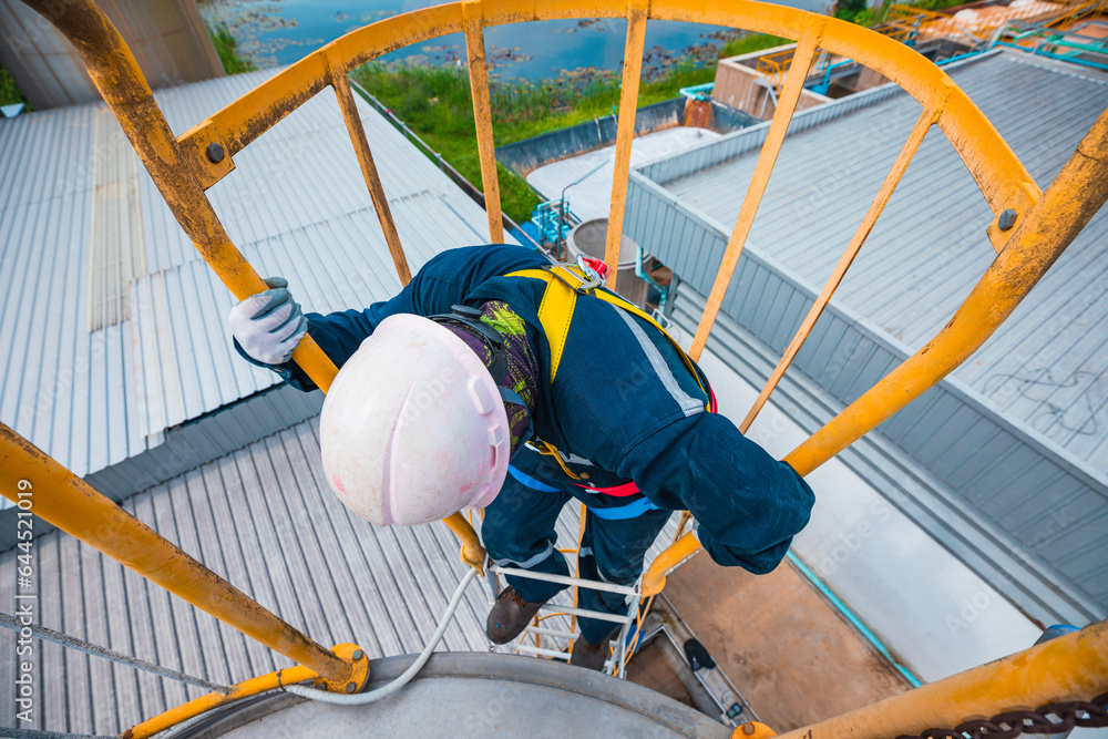 Top view male worker climbs down the ladder inspection stainless tank ...