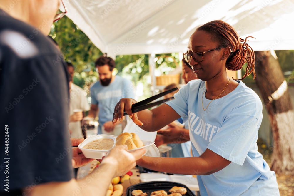 Detailed image of black woman at a food drive sharing free warm meals ...