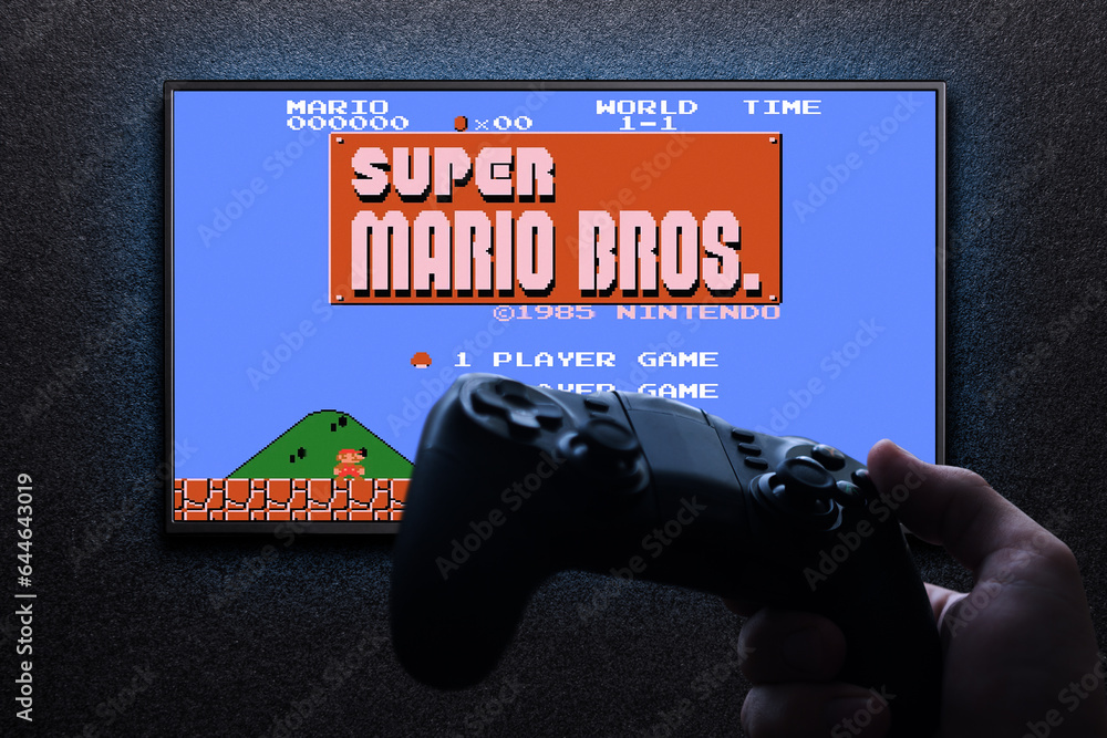 Super Mario Bros classic video game on TV with gamepad in hand on black ...