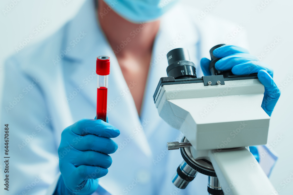 Close up dedicated hematology lab technician scrutinizing blood sample ...
