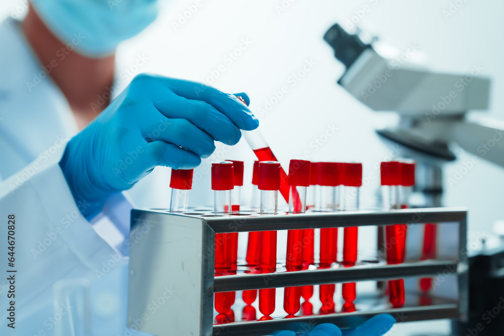 Close up dedicated hematology lab technician scrutinizing blood sample ...