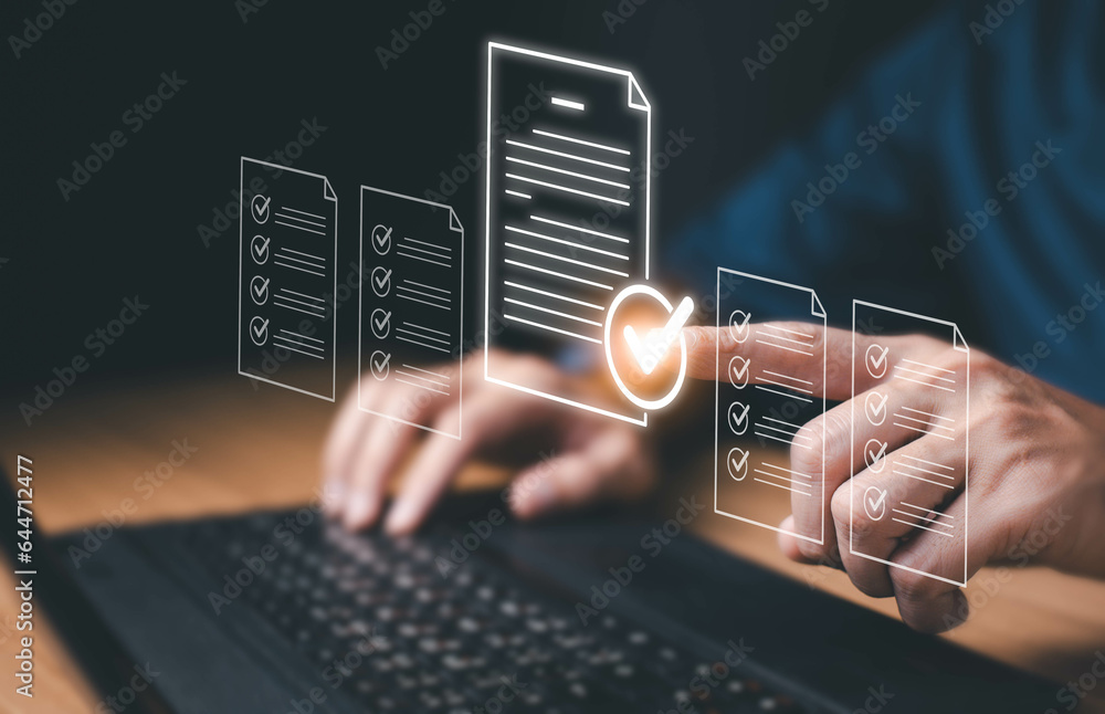 Businessman using laptop computer with correct sign mark and document ...