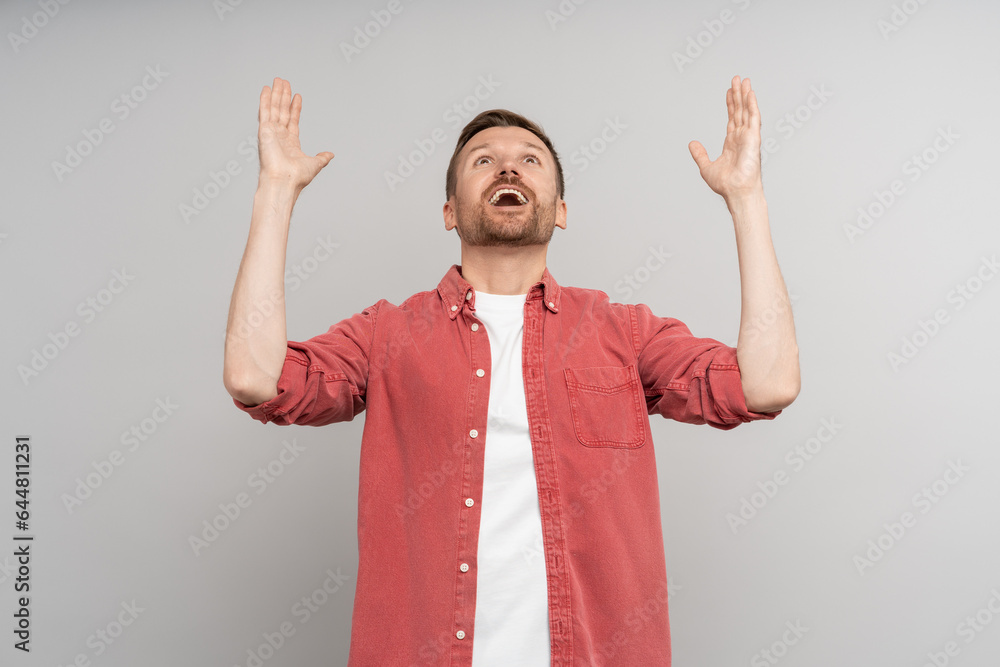 Smiling man triumphant raised hands look up rejoicing at victory ...