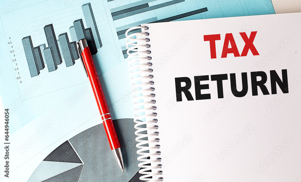 TAX RETURN text on a notebook with pen on a chart background Stock ...