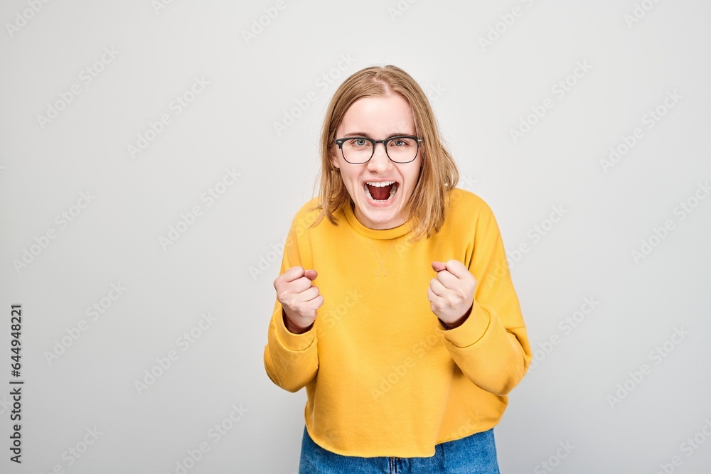 Portrait of angry schoolgirl yelling clenching fists isolated on white ...