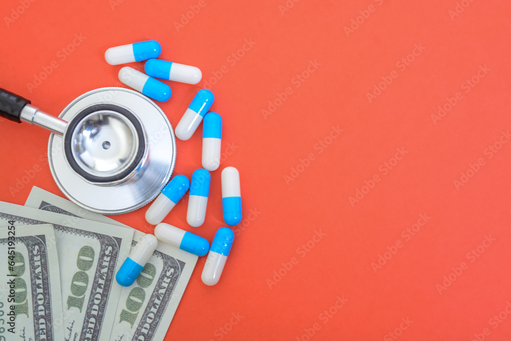 The intersection of pill capsules, a stethoscope, and money underscores ...