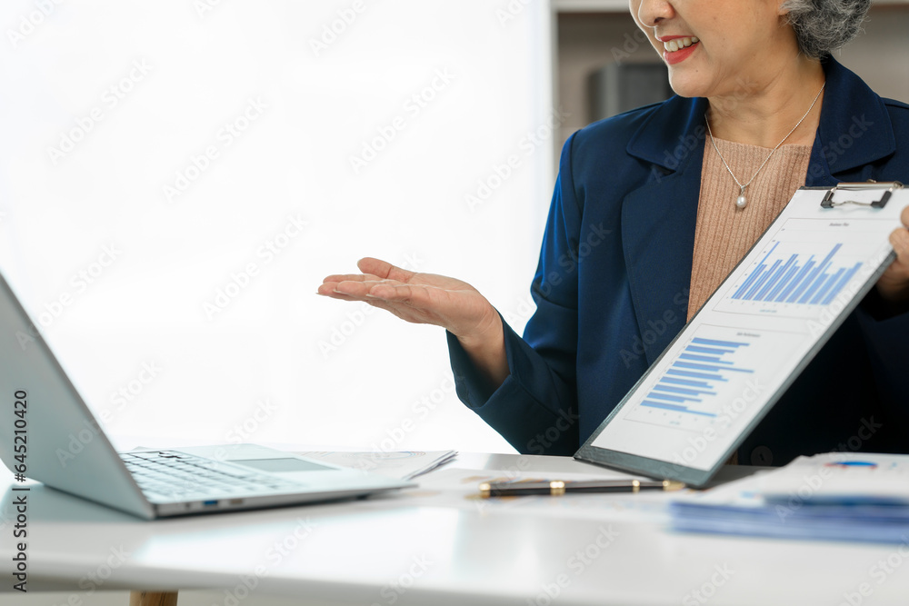 Mature businesswoman focused and dedicated while working at her office ...