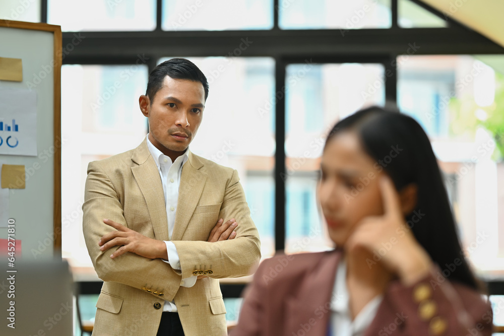 Strict millennial male boss look at stressed female employee at ...