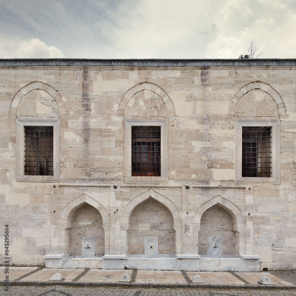 External stone wall of 16th century historic Atik Valide Mosque with ...