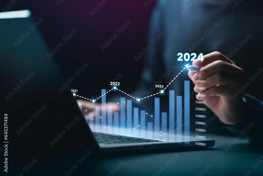 Businessman analyzes the graph of trend market growth in 2024 and plans ...