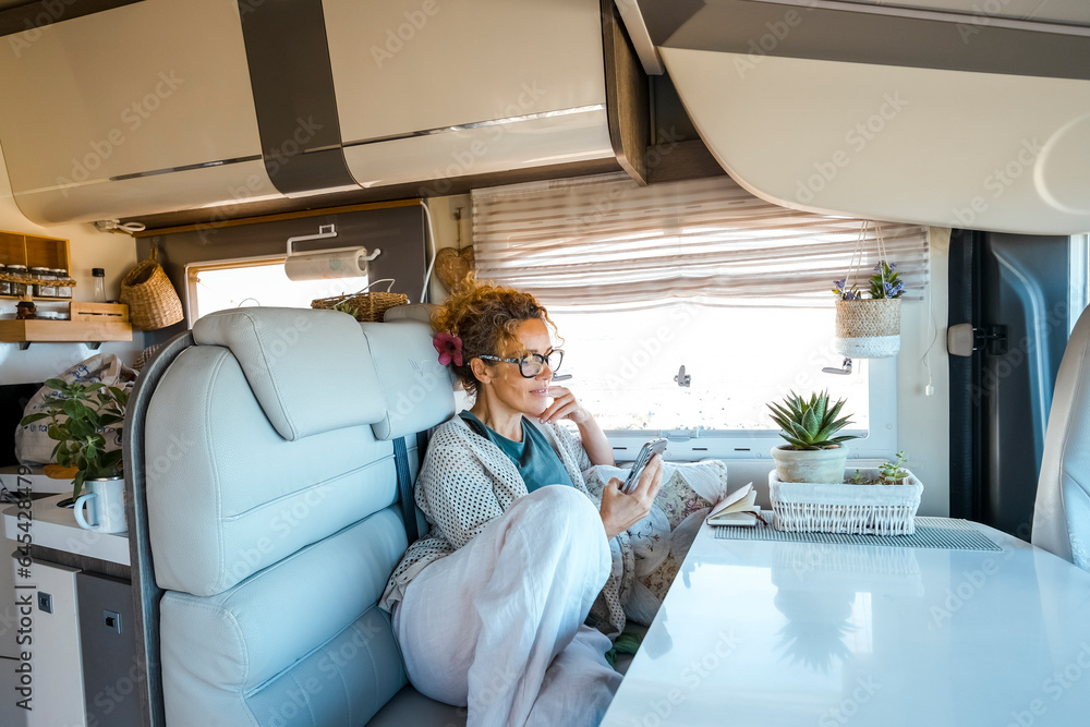 Adult woman relaxing inside a modern luxury camper van rv vehicle ...