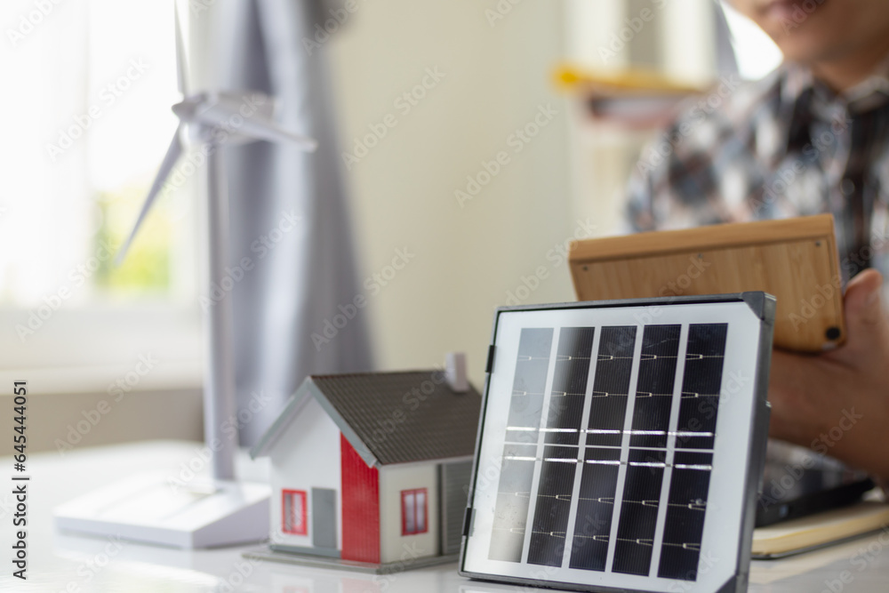 On desk of engineers lay model of house And solar panels to use in ...