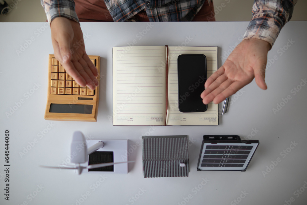On desk of engineers lay model of house And solar panels to use in ...