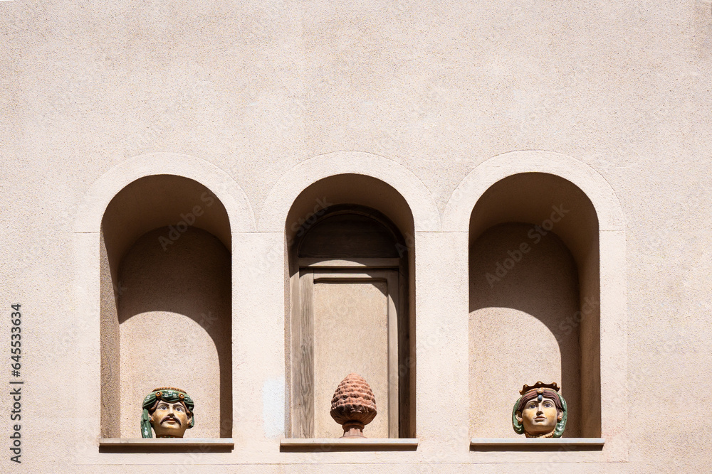 three arched wall niches in a building wall with ornamental sicilian ...