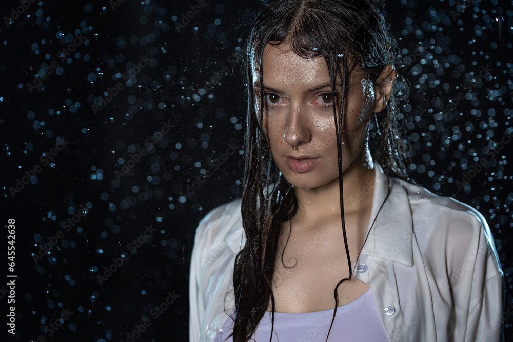 young woman in the rain, getting wet through, wet clothes and water ...