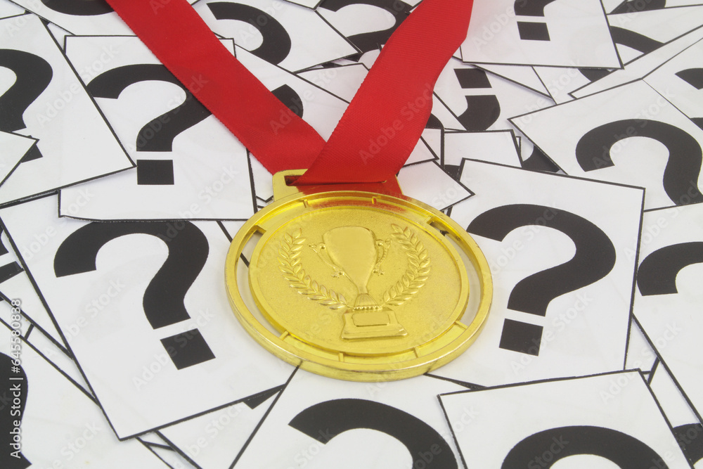 Golden medal with red ribbon on many question marks background. Stock ...