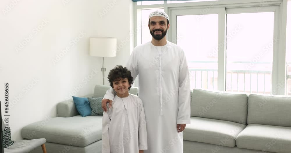 Portrait of man and 5s boy in traditional Muslim wear. Loving father in ...