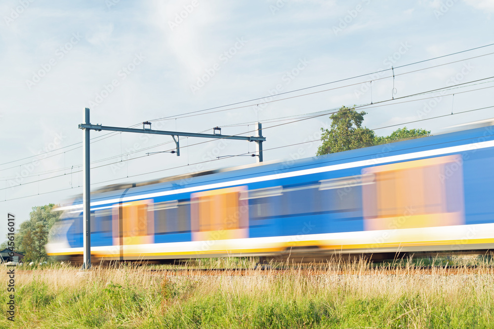 Sprinter train rushes by at high speed, blurred by long exposure in ...