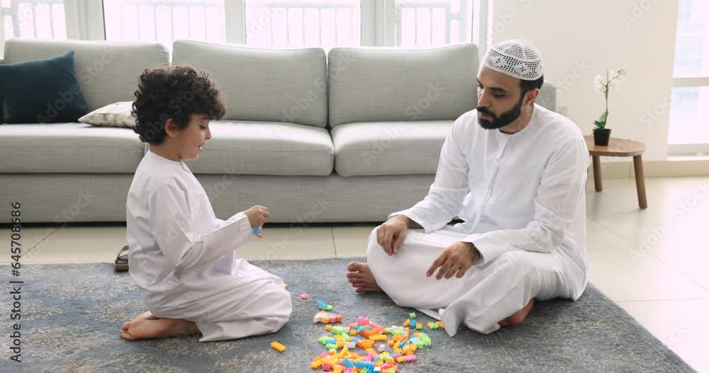 Muslim family spend time together play plastic blocks sit on floor in ...
